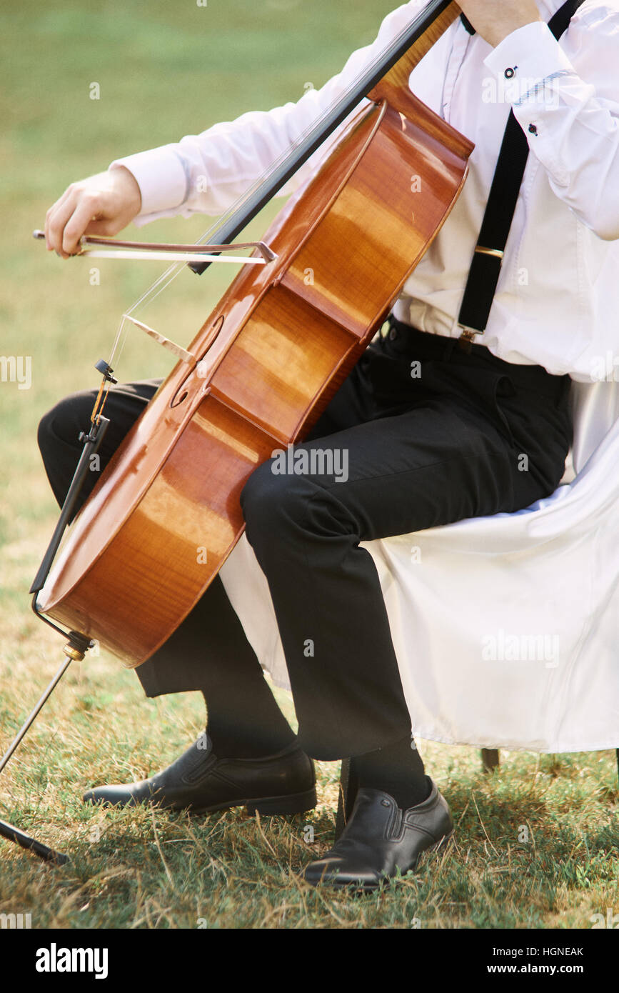 Young man playing cello outside. Cellist playing classical music on ...