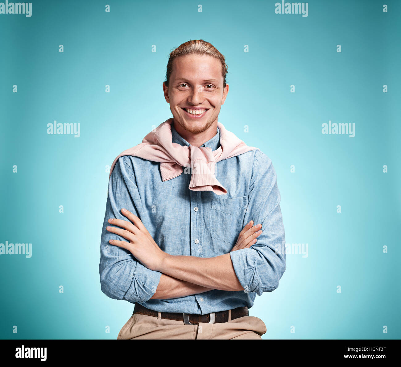 Happy excite young man smiling over blue background Stock Photo - Alamy