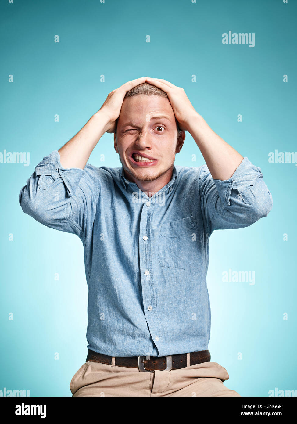 The disappointed young man over blue background Stock Photo - Alamy