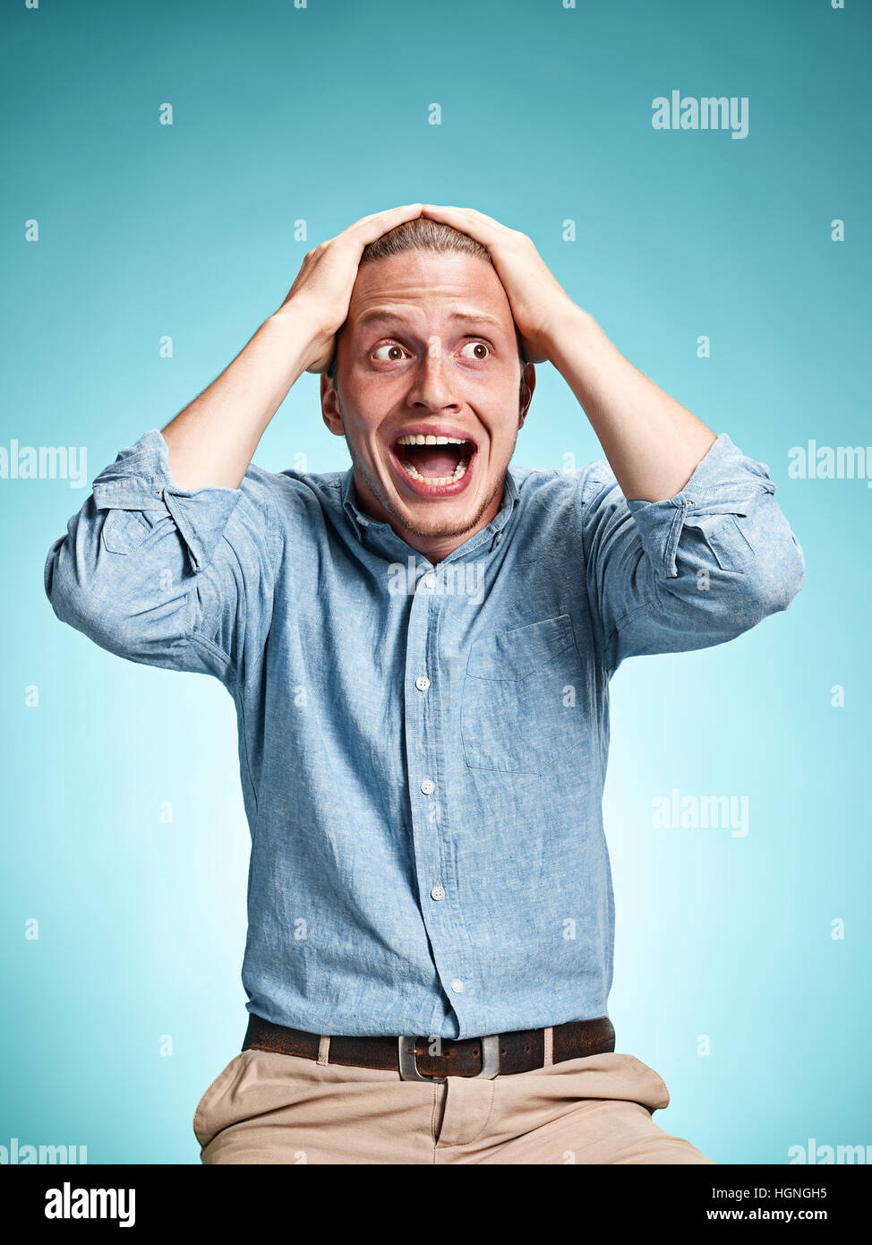The disappointed young man over blue background Stock Photo - Alamy