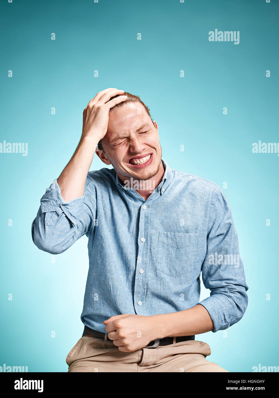 The disappointed young man over blue background Stock Photo - Alamy