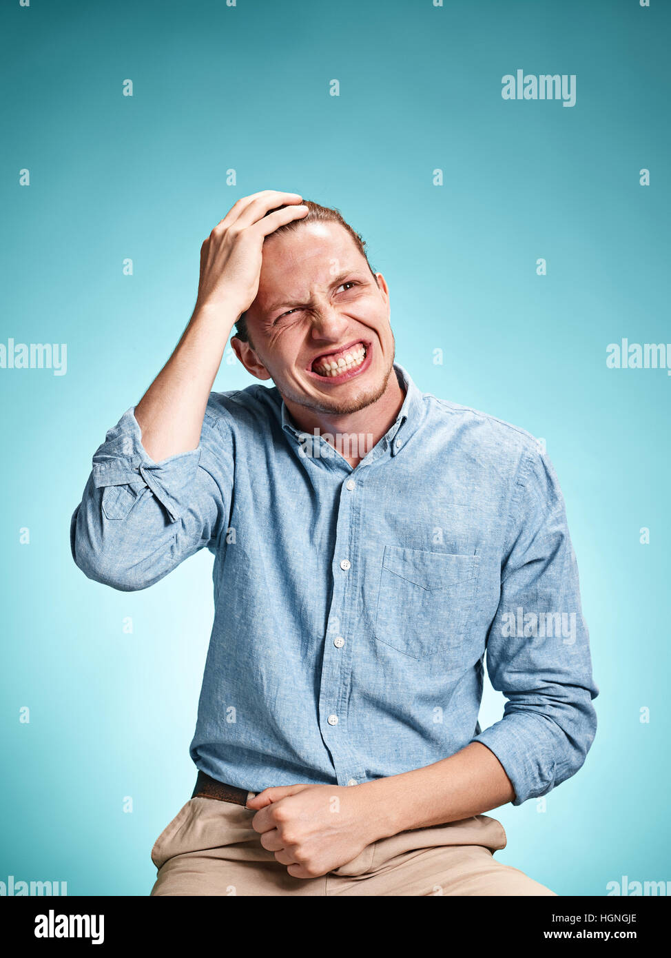 The disappointed young man over blue background Stock Photo - Alamy