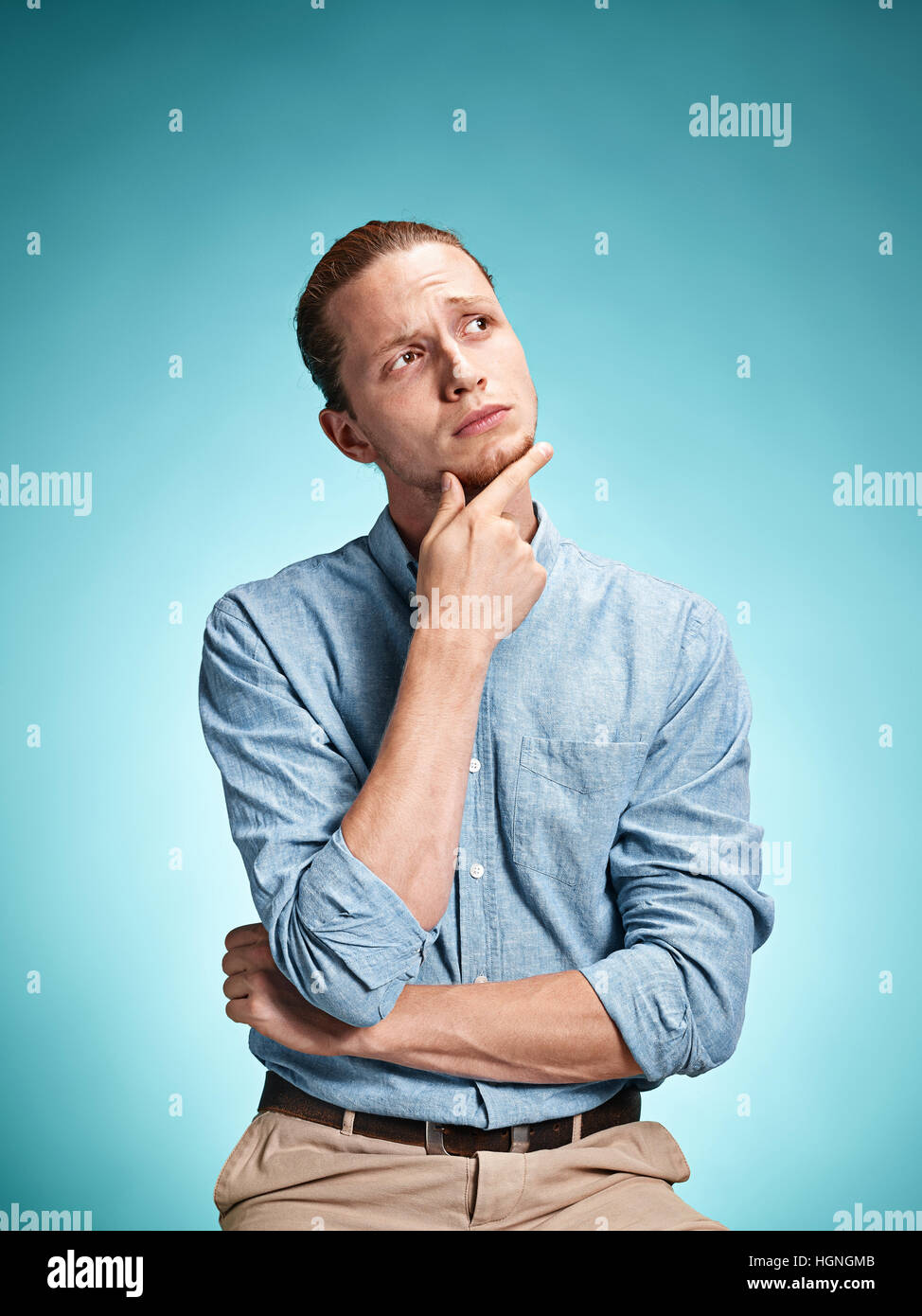 The serious young man over blue background Stock Photo - Alamy