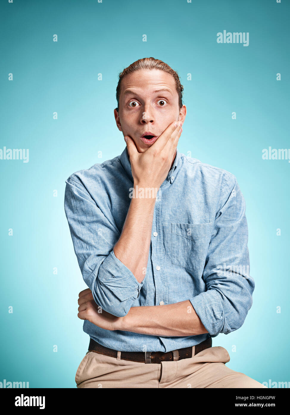 The surprised young man over blue background Stock Photo - Alamy