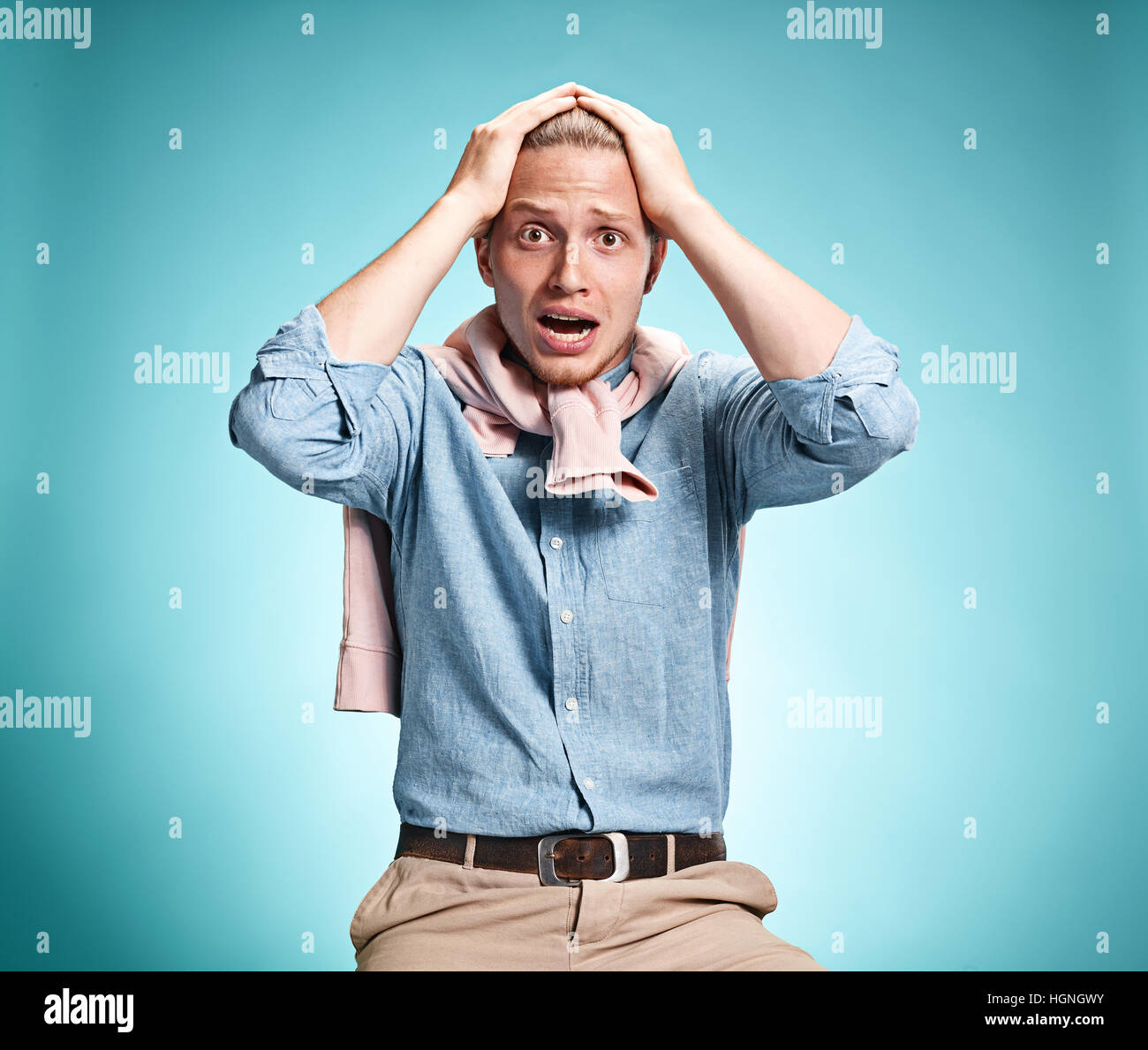 The surprised young man over blue background Stock Photo - Alamy
