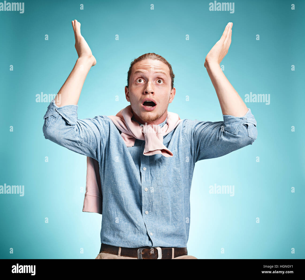 The surprised young man over blue background Stock Photo - Alamy