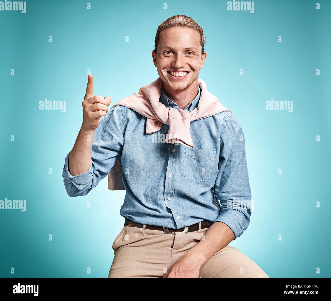 Happy excite young man smiling over blue background Stock Photo - Alamy