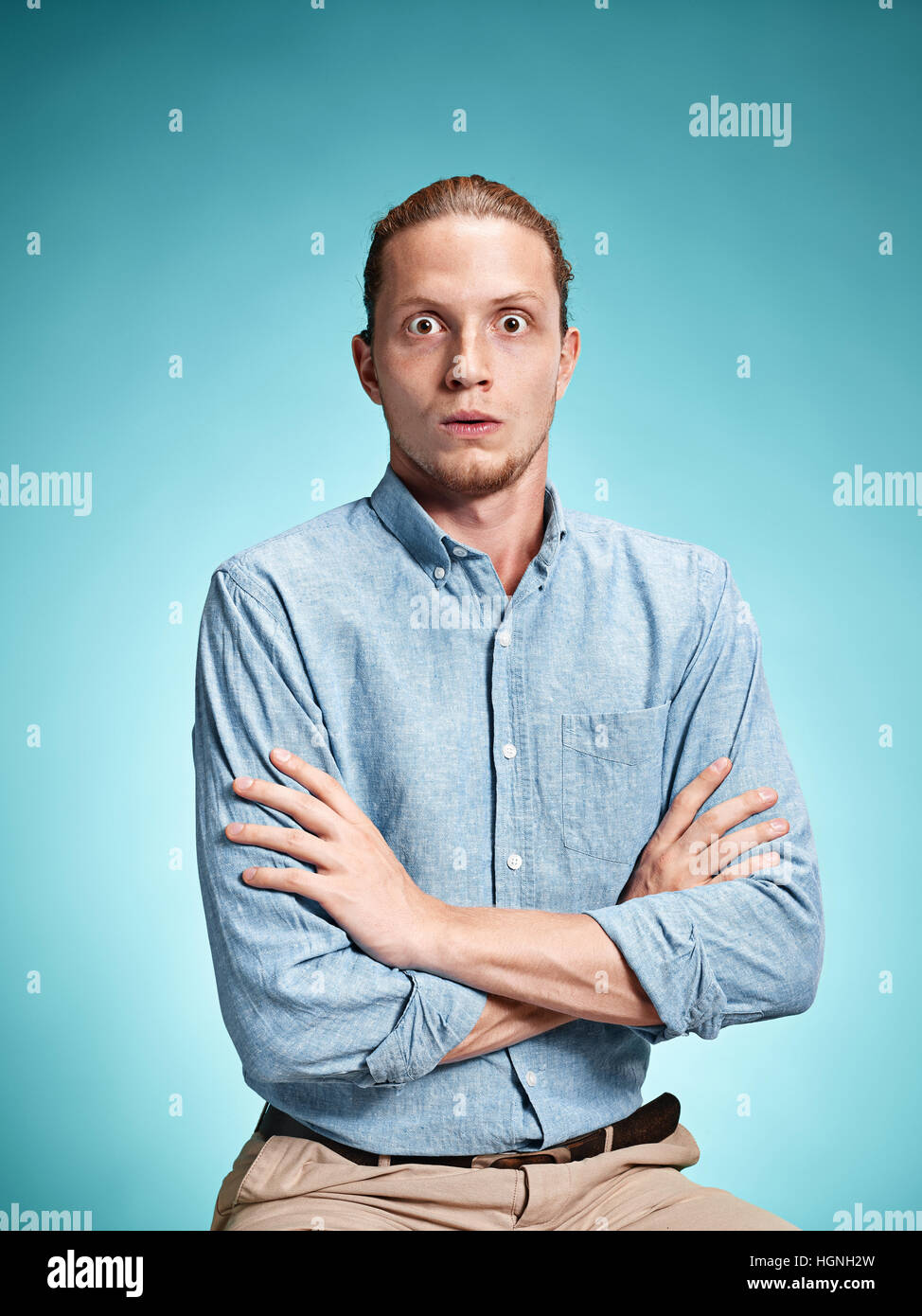 The surprised young man over blue background Stock Photo - Alamy