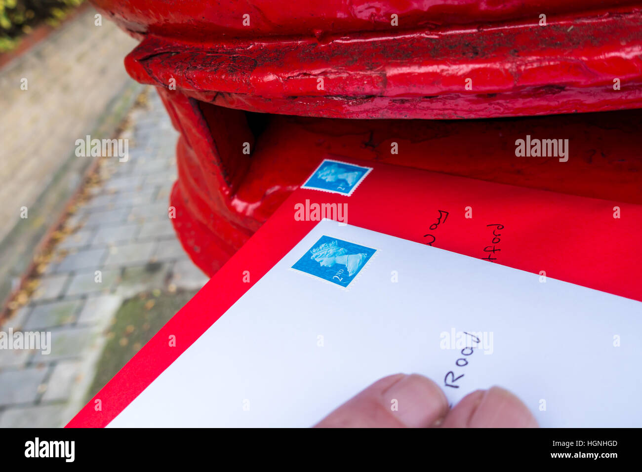 Posting a letter in a red british post box Stock Photo - Alamy Posting a letter in a red british post box Stock Photo - Alamy