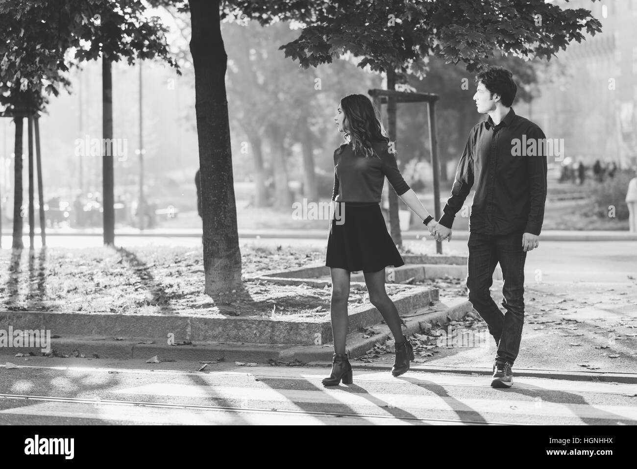 Young beautiful couple in love walking hand in hand in the city - first ...