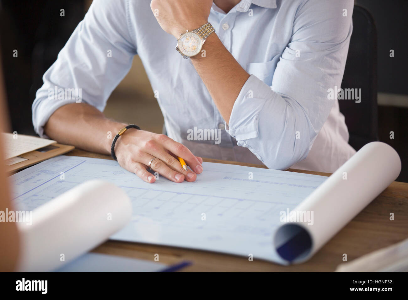 Architect looking at blueprint Stock Photo - Alamy