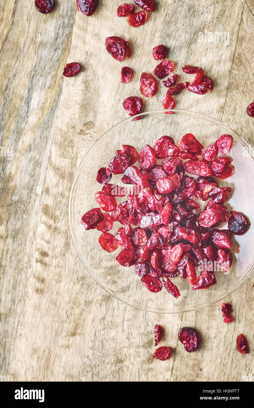 Dried cranberries in the glass bowl on the wooden table Stock Photo - Alamy