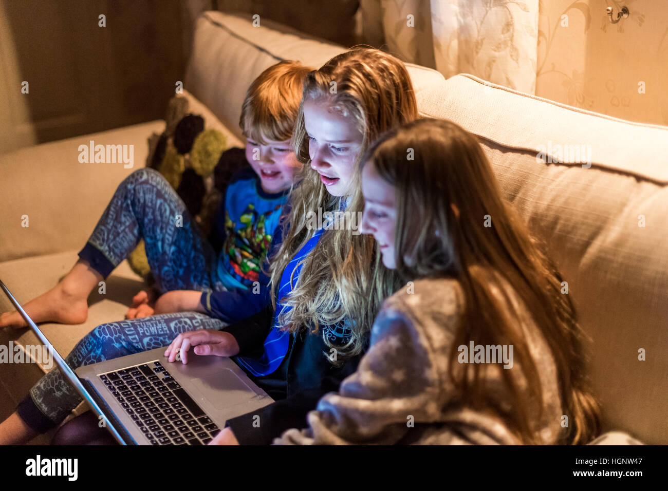 Children sat at home looking at a computer laughing at a TV show Stock ...
