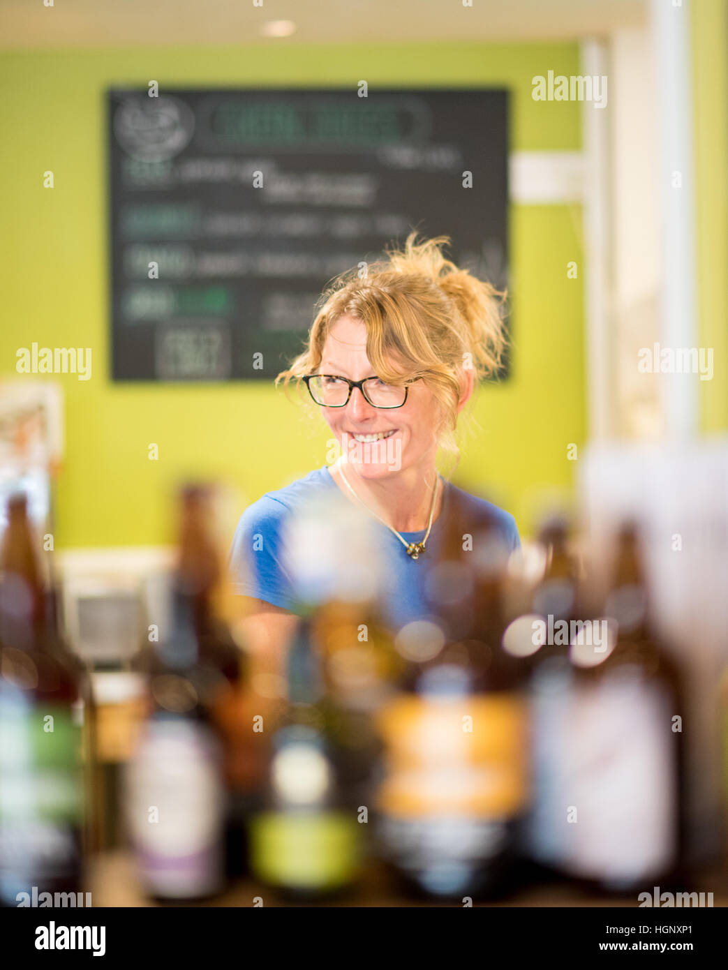 A smiling lady in a cafe with chalkboard in the background Stock Photo ...