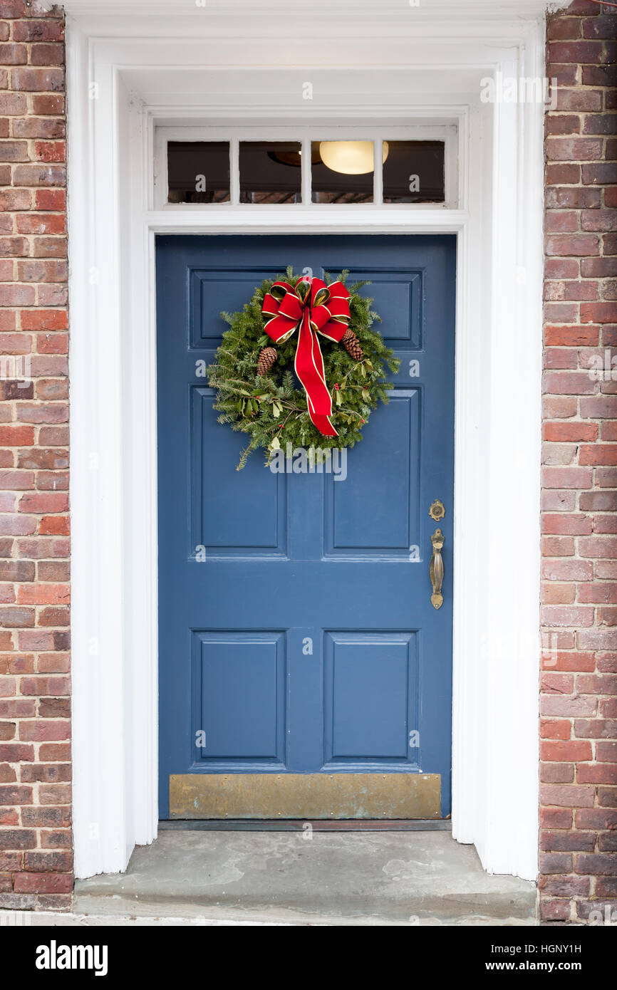 A beautiful door is decorated for Christmas with an evergreen wreath ...