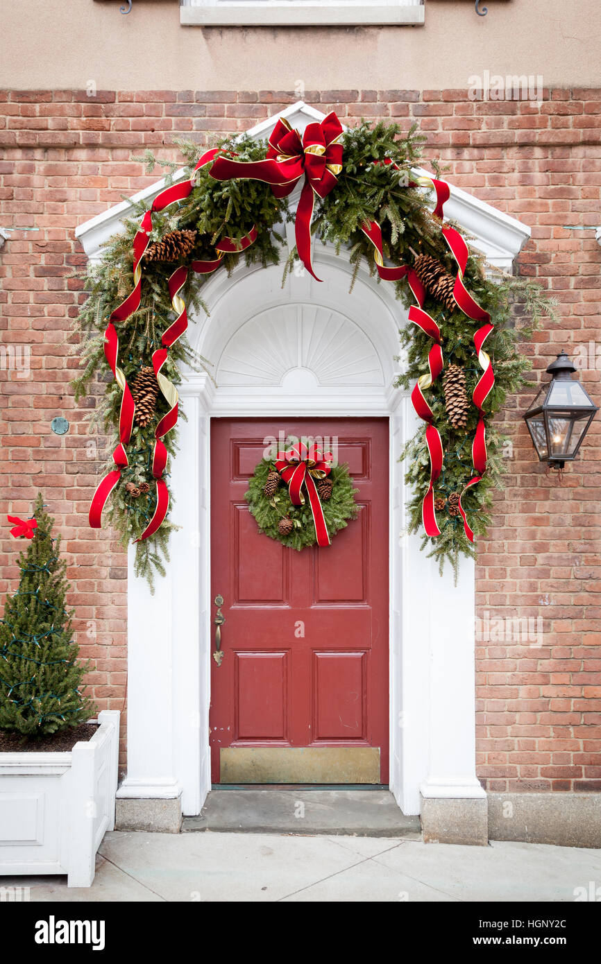 A beautiful door is decorated for Christmas with an evergreen wreath ...