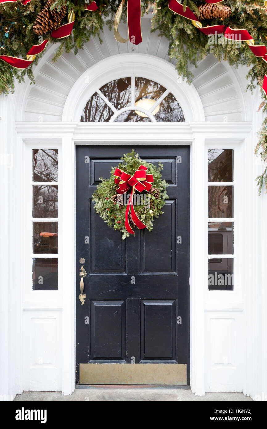 A beautiful door is decorated for Christmas with an evergreen wreath ...