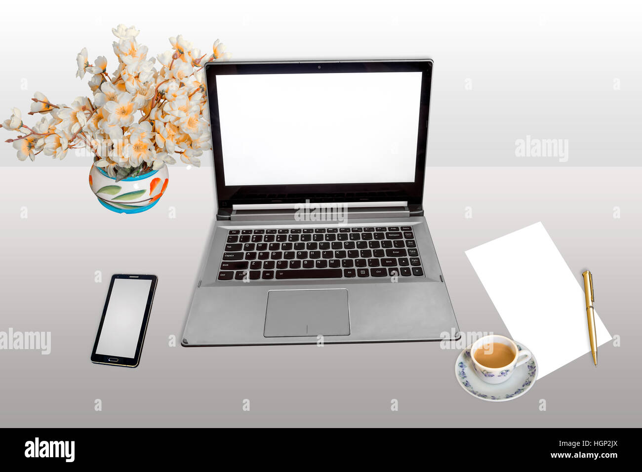 Workplace with laptop computer, smart phone, blank paper and pen with ...