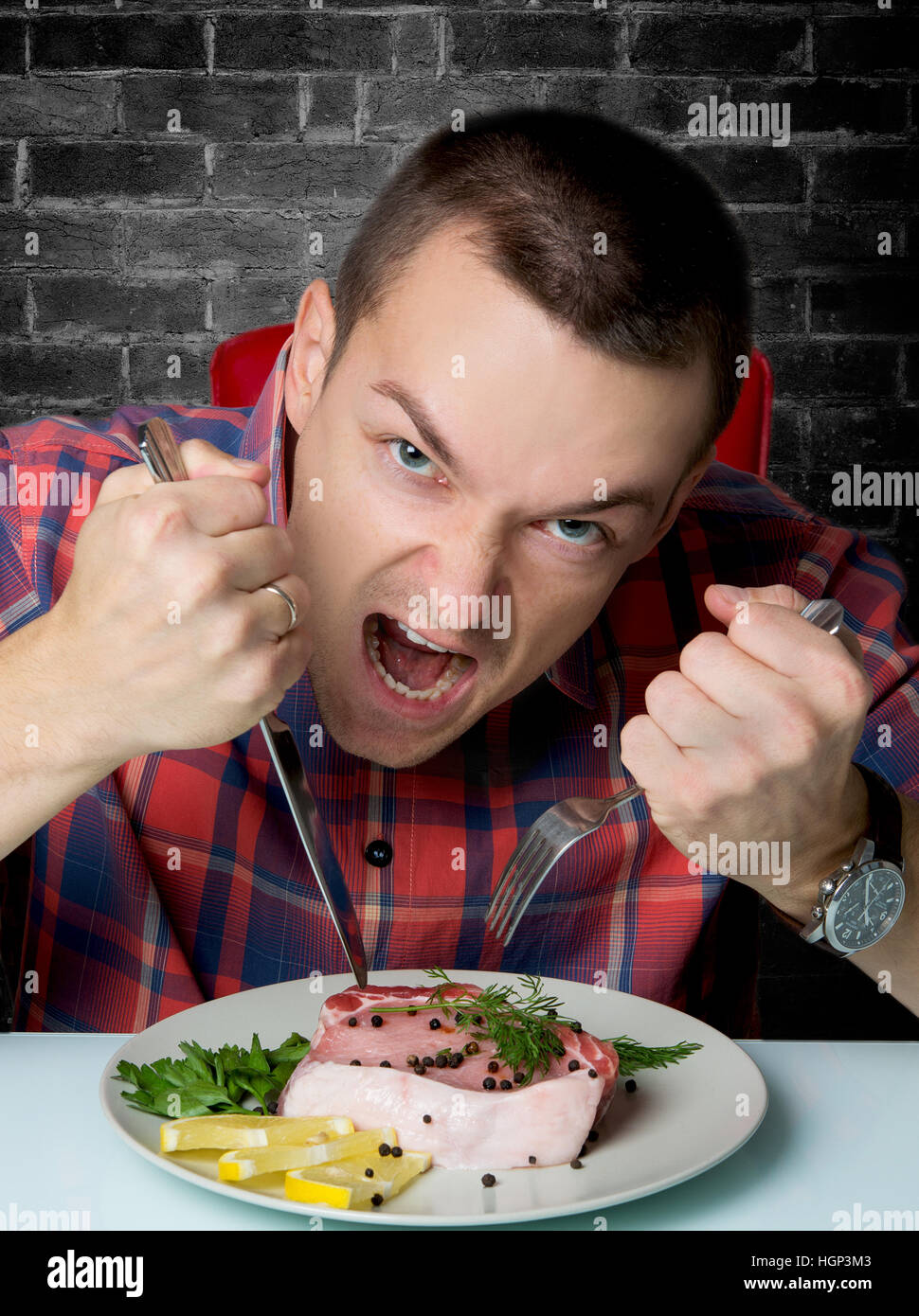 hungry man eats meat Stock Photo - Alamy