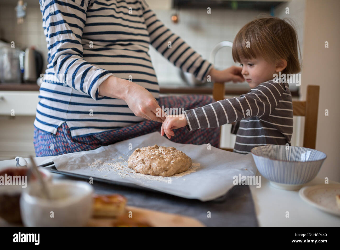 Pregnant mom and making bread in the kitchen with her son Toddler ...
