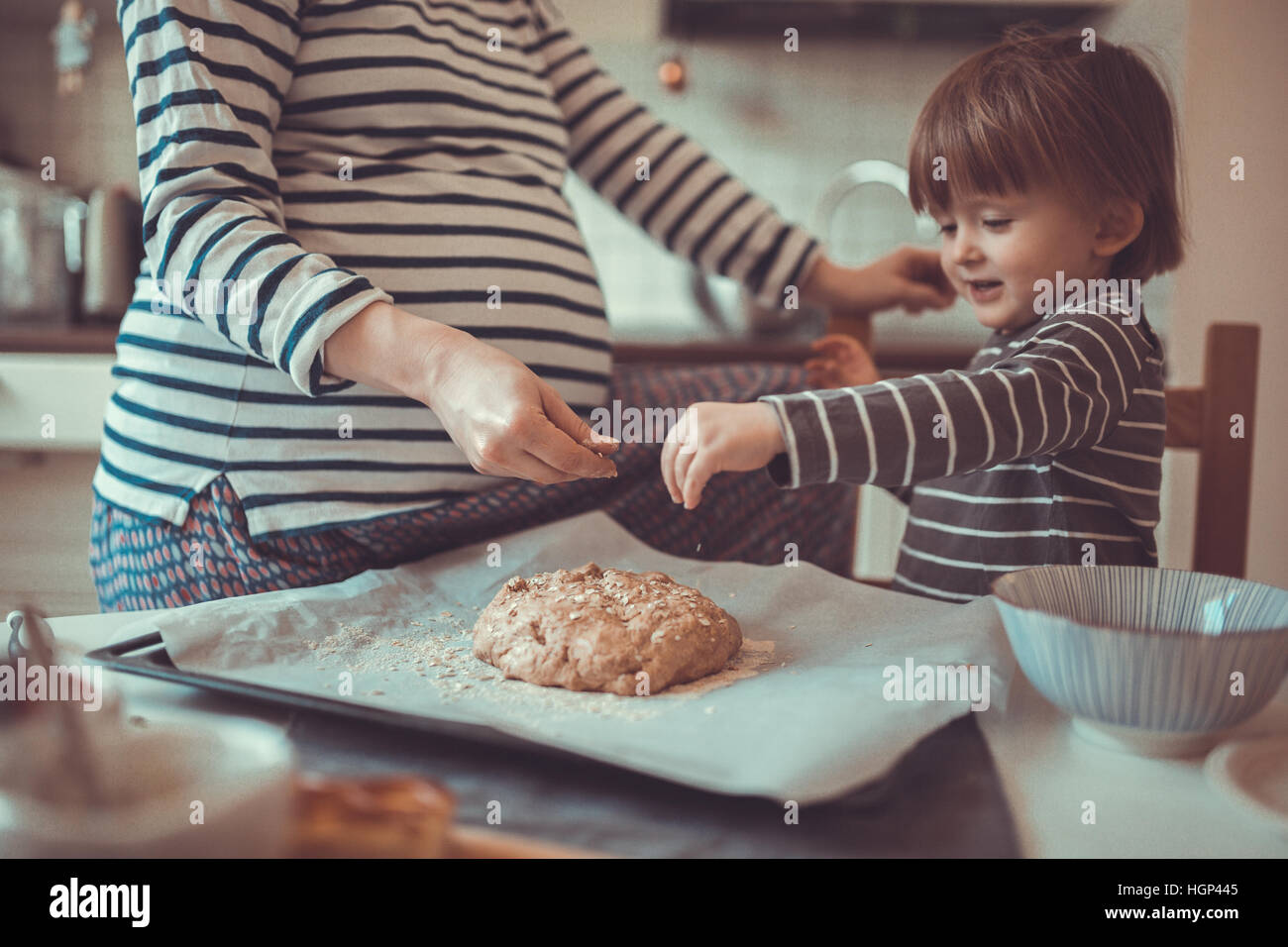 Pregnant mom and making bread in the kitchen with her son Toddler ...