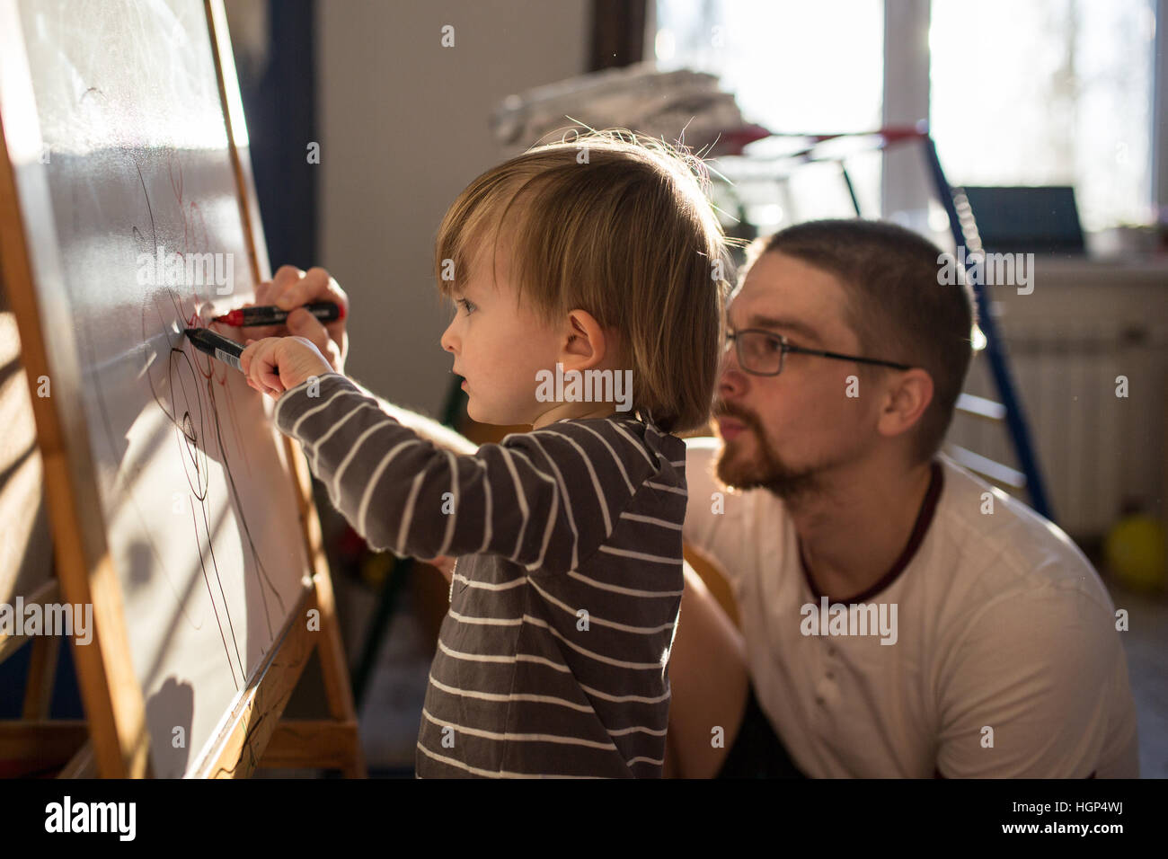 Dad and son together paint on Easel. Real interior, toning soft focus ...
