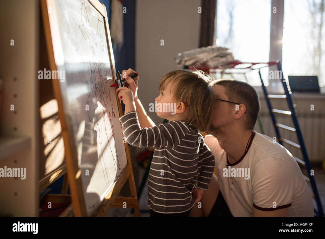 Dad and son together paint on Easel. Real interior, toning soft focus ...