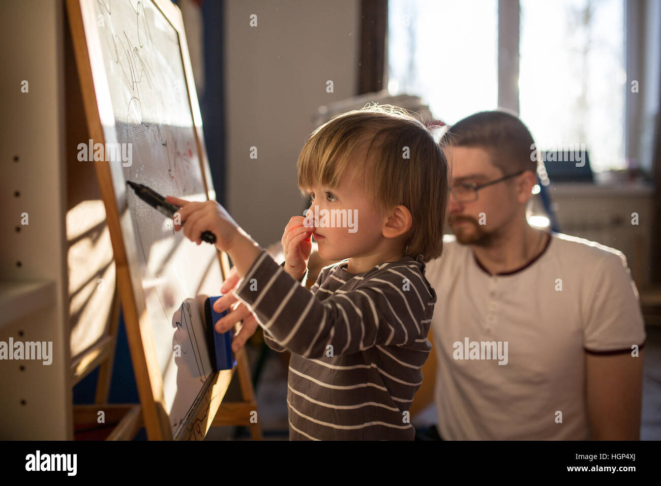 Dad and son together paint on Easel. Real interior, toning soft focus ...