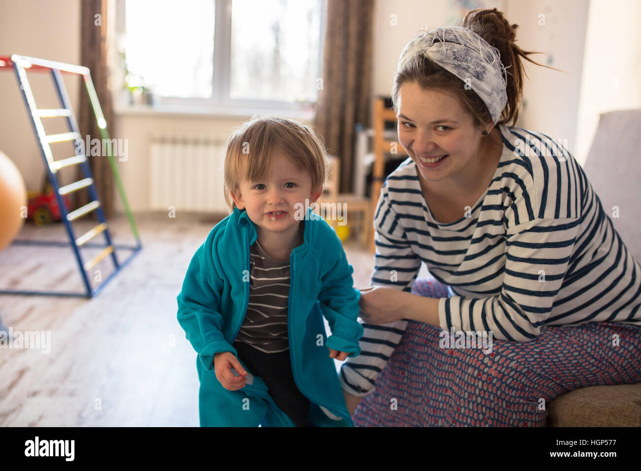 Mom puts her son, a boy Toddler clothes coveralls using mothers, the real interior, lifestyle ...