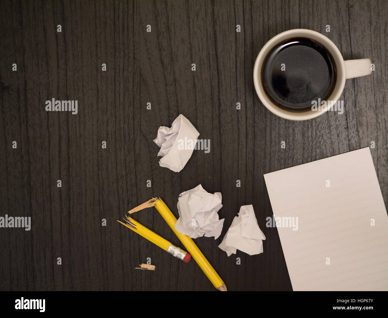 Dark surface, white,crumpled paper broken pencil, coffee, frustration ...