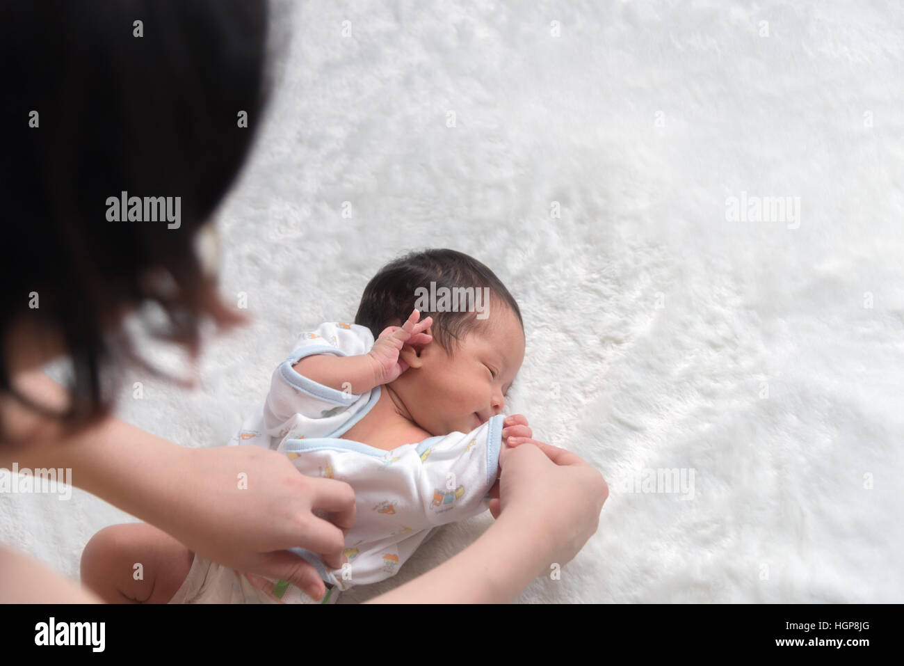 Mother changing babies cloth Stock Photo - Alamy