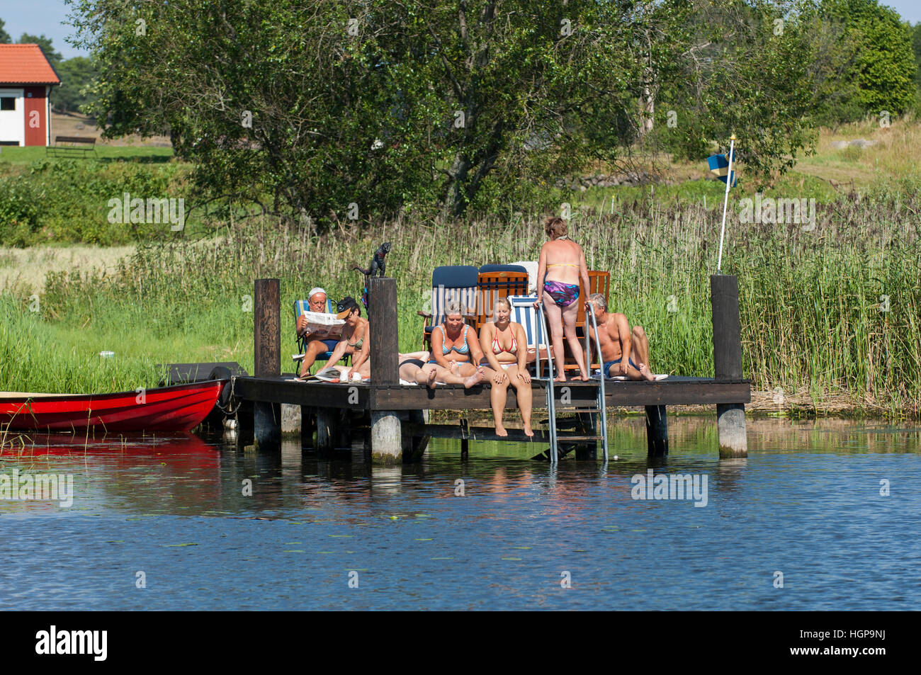 People sit on the dock and enjoy the warm sun Stock Photo - Alamy