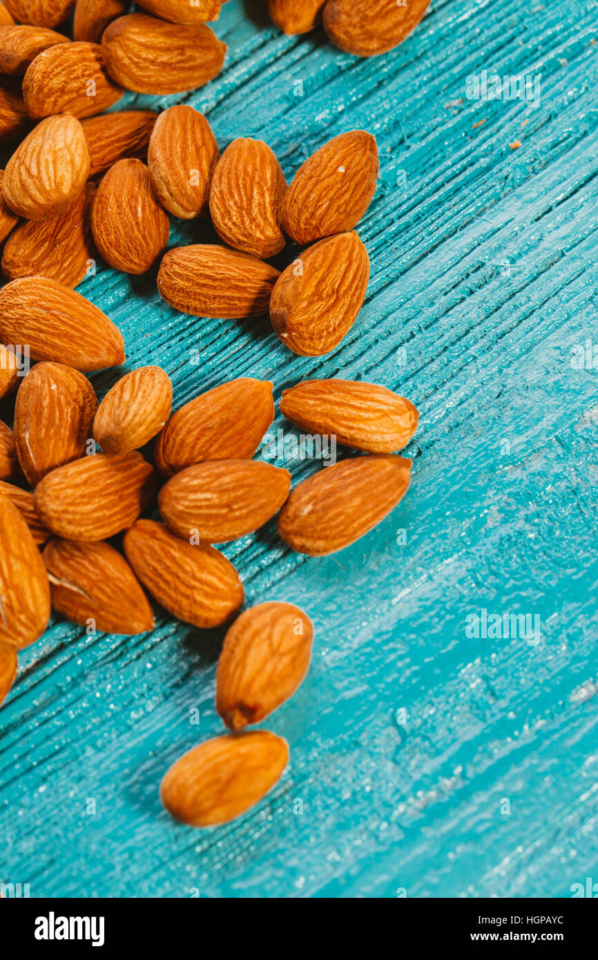 handful of almonds on a blue wooden background Stock Photo - Alamy