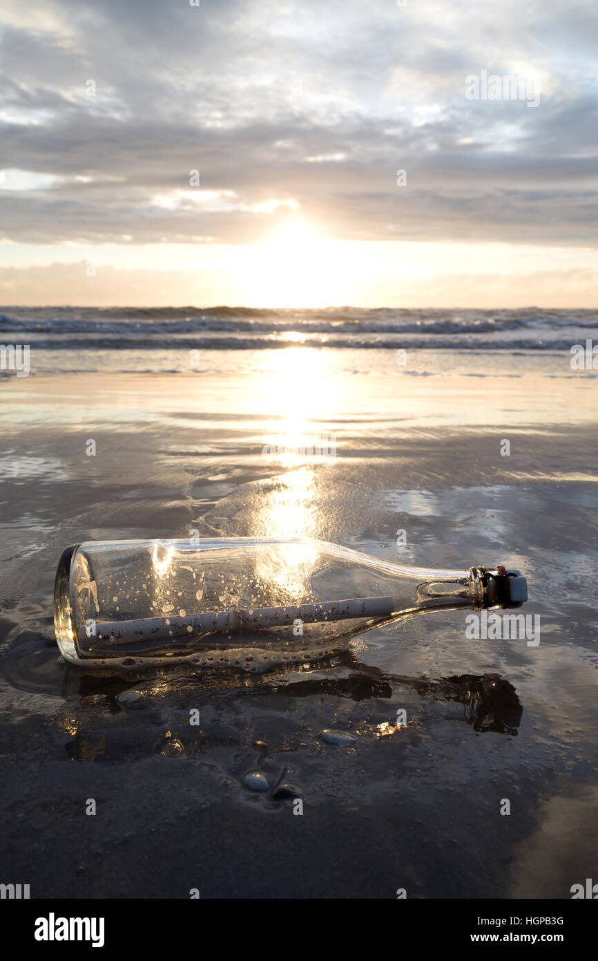 message in a bottle stranded on the beach at sunset Stock Photo - Alamy