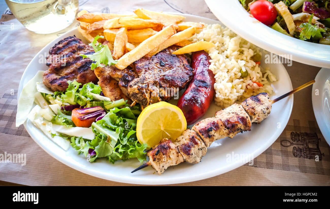 Mix meat plate with french fries, Greek food Stock Photo - Alamy