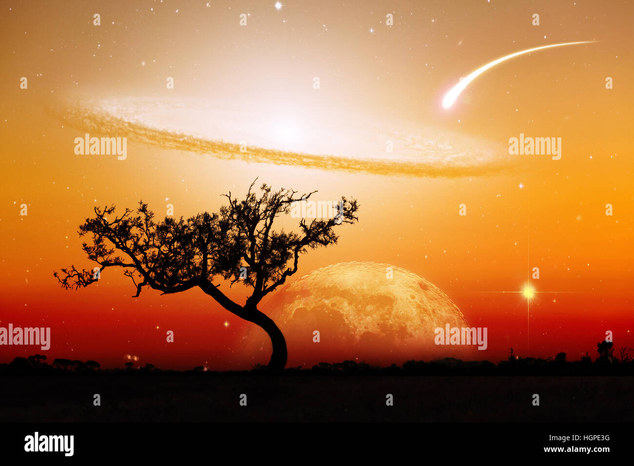 Unreal landscape of lone tree silhouette with planet and galaxy visible ...