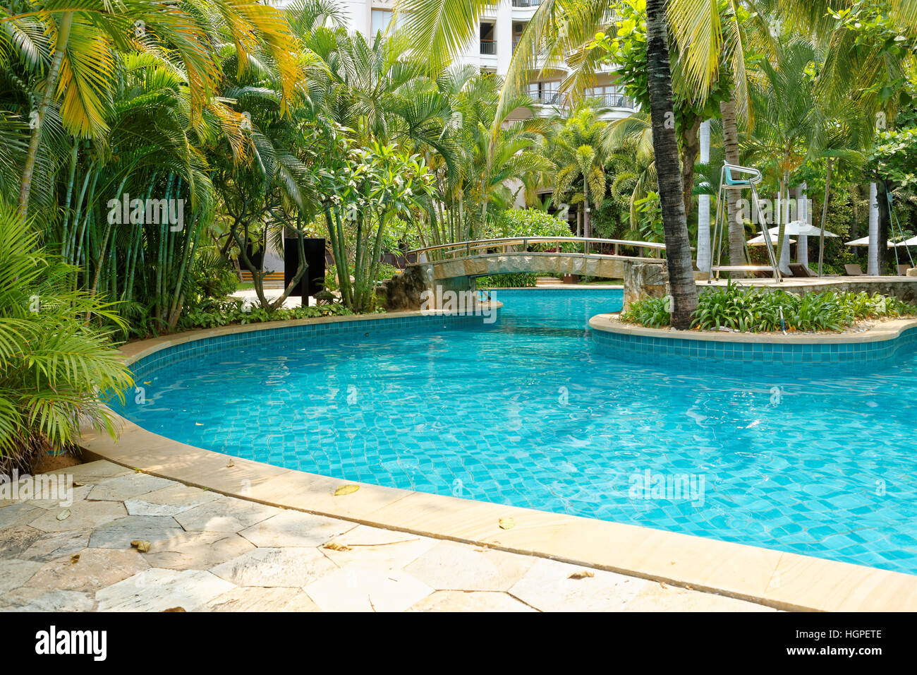 Hotel swimming pool in garden of tropical trees Stock Photo - Alamy
