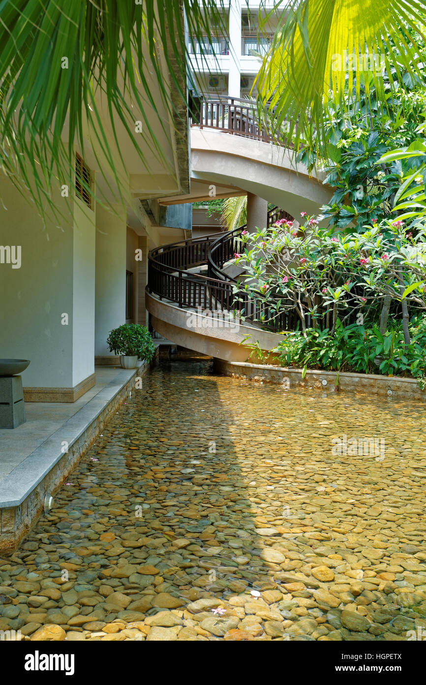 Inner court of the large hotel with tropical trees, flowers, gardens ...