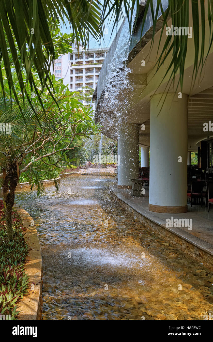 Inner court of the large hotel with tropical trees, flowers, gardens ...