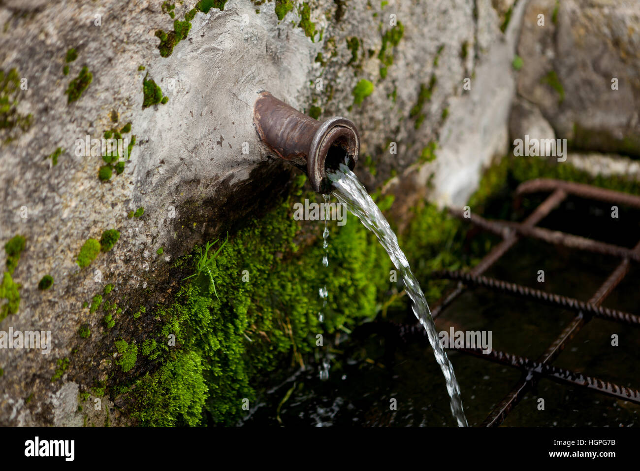 Pipe clean water pouring from a natural source Stock Photo - Alamy