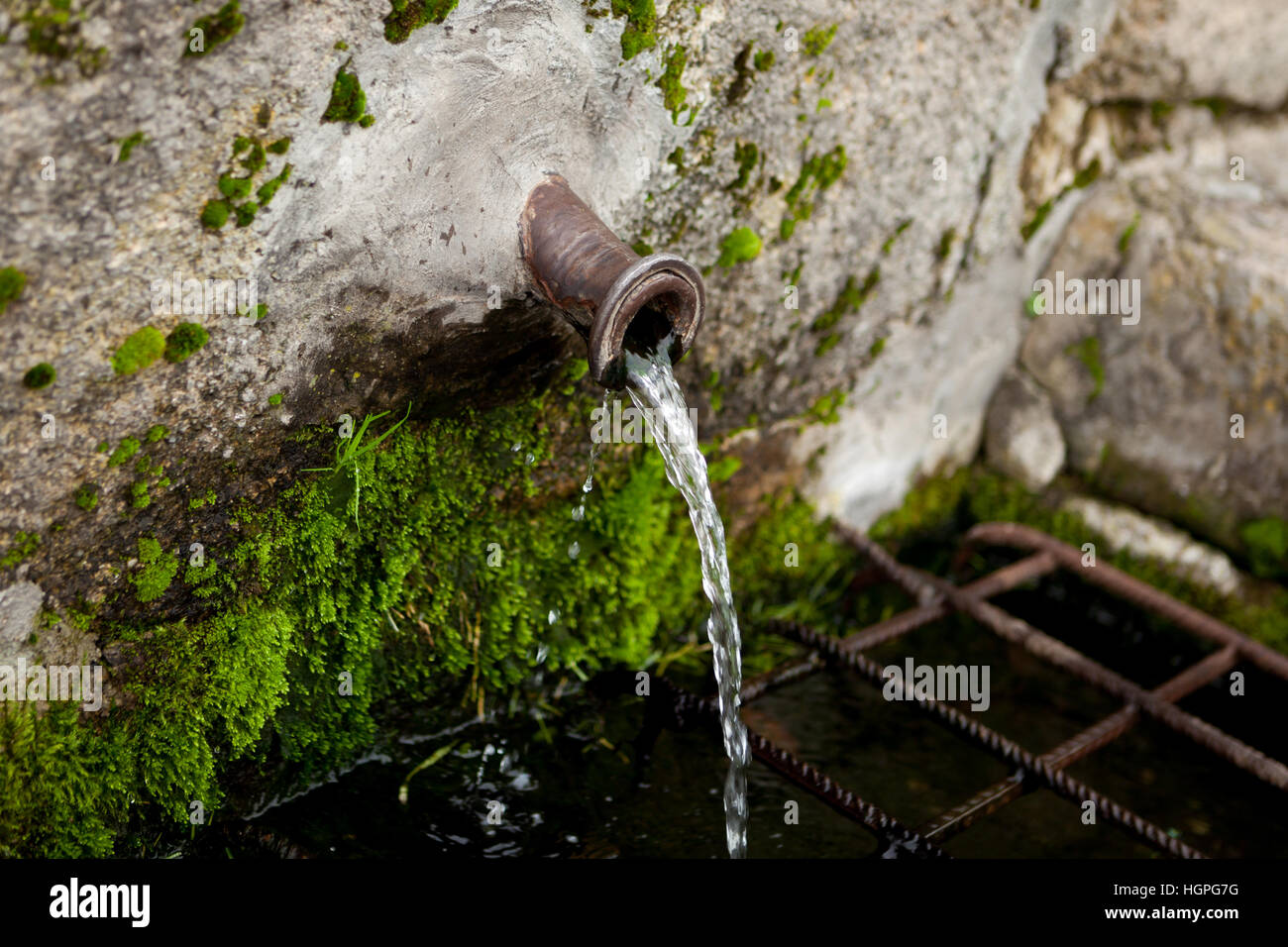 Pipe clean water pouring from a natural source Stock Photo - Alamy