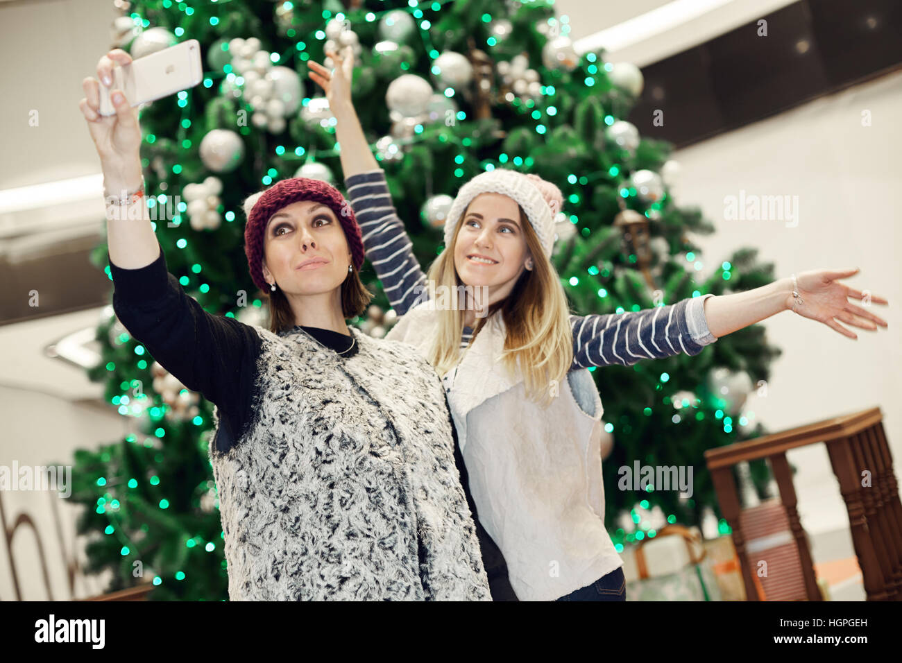 Two girls make selfie near the Christmas tree Stock Photo - Alamy