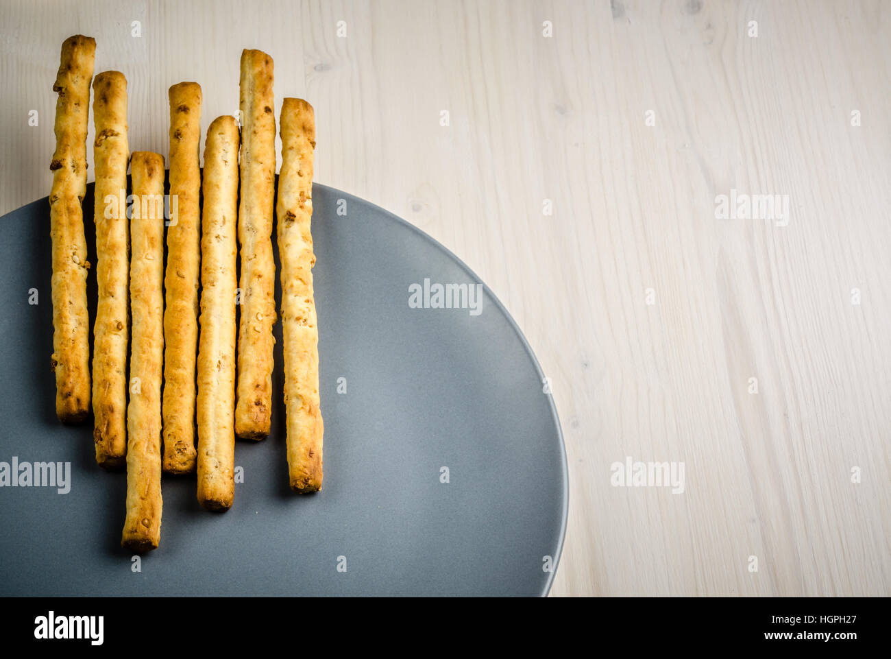 rustic breadsticks in a dish on wood table, close up, background Stock ...
