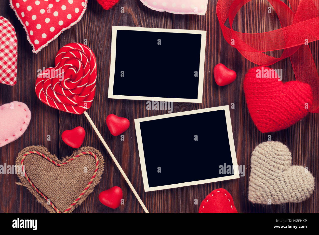 Valentines day hearts, candies and photo frames over wooden background ...