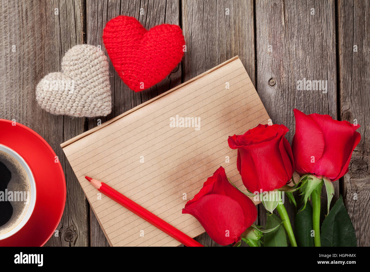 Love letter notepad, red roses and coffee cup on wooden table ...
