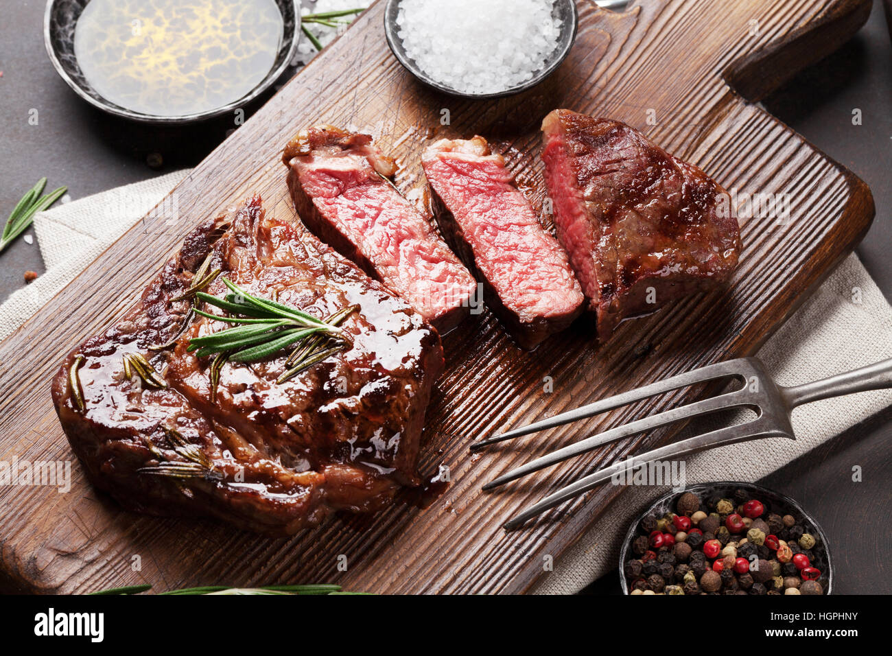 Grilled ribeye beef steak, herbs and spices on cutting board Stock ...