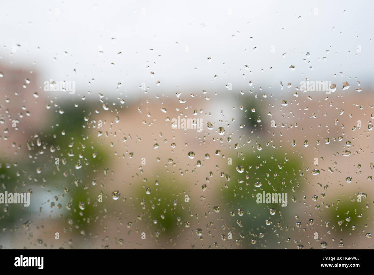 Raindrops on a window glass of a dwelling, where part of the city is ...