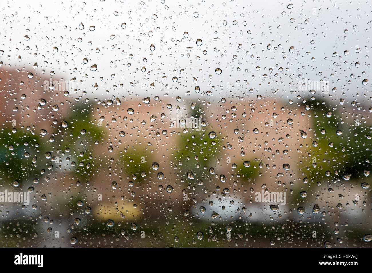 Raindrops on a window glass of a dwelling, where part of the city is ...