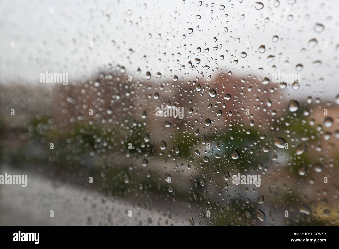 Raindrops on a window glass of a dwelling, where part of the city is ...