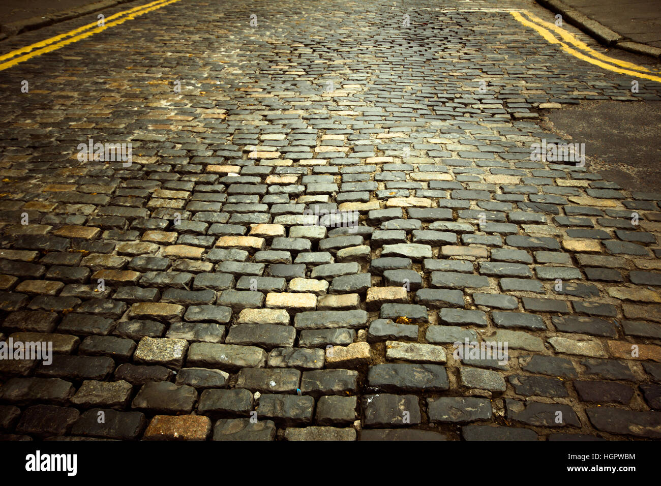 Old Cobblestone street with yellow line Stock Photo - Alamy